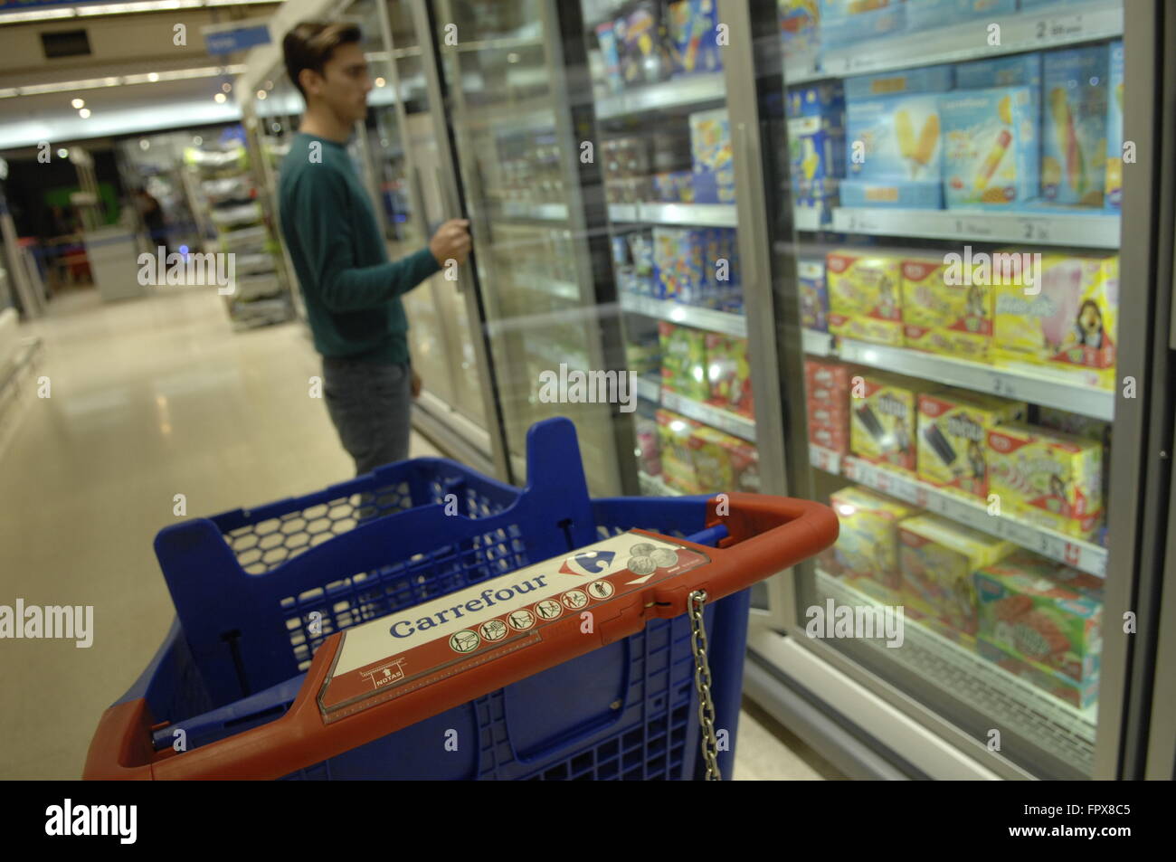 Customer looking at produce in the frozen food section of Carrefour ...