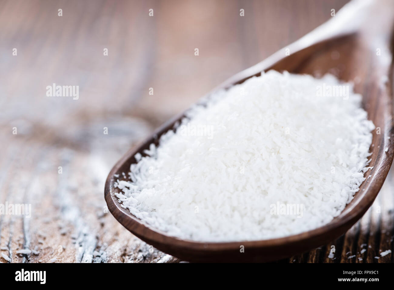 Grated Coconut (detailed close-up shot) on wooden background Stock ...