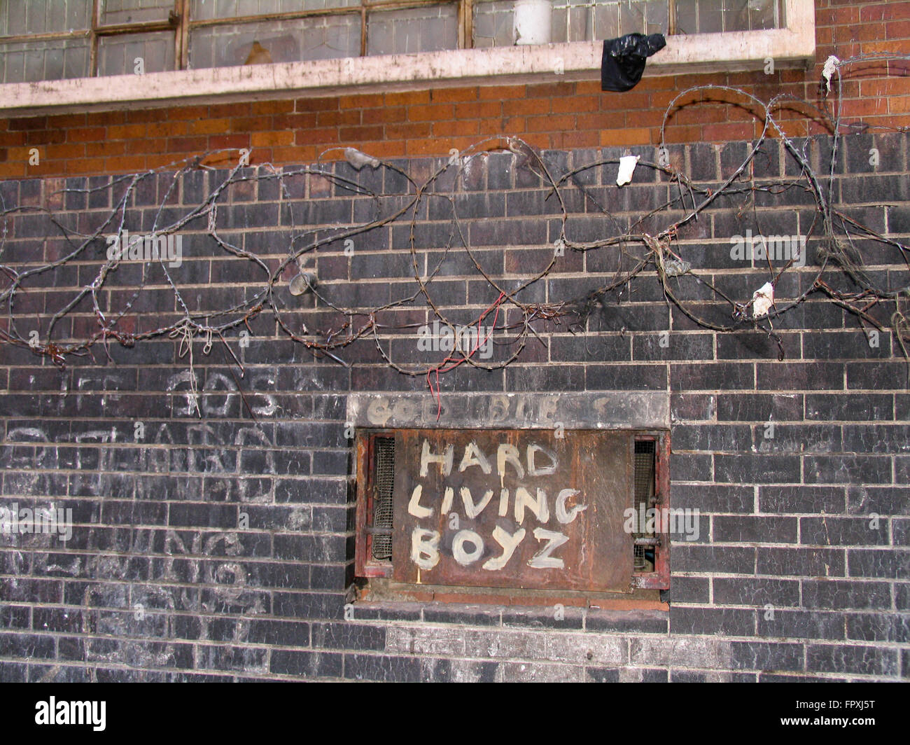Brick wall with barbed wire and graffiti Stock Photo - Alamy