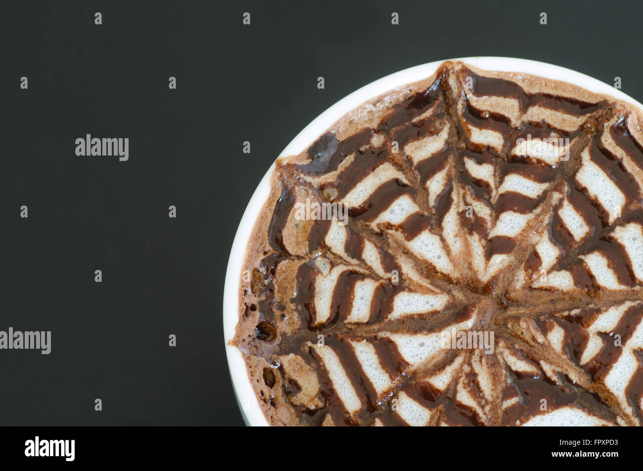 a cup of latte art on black background Stock Photo - Alamy