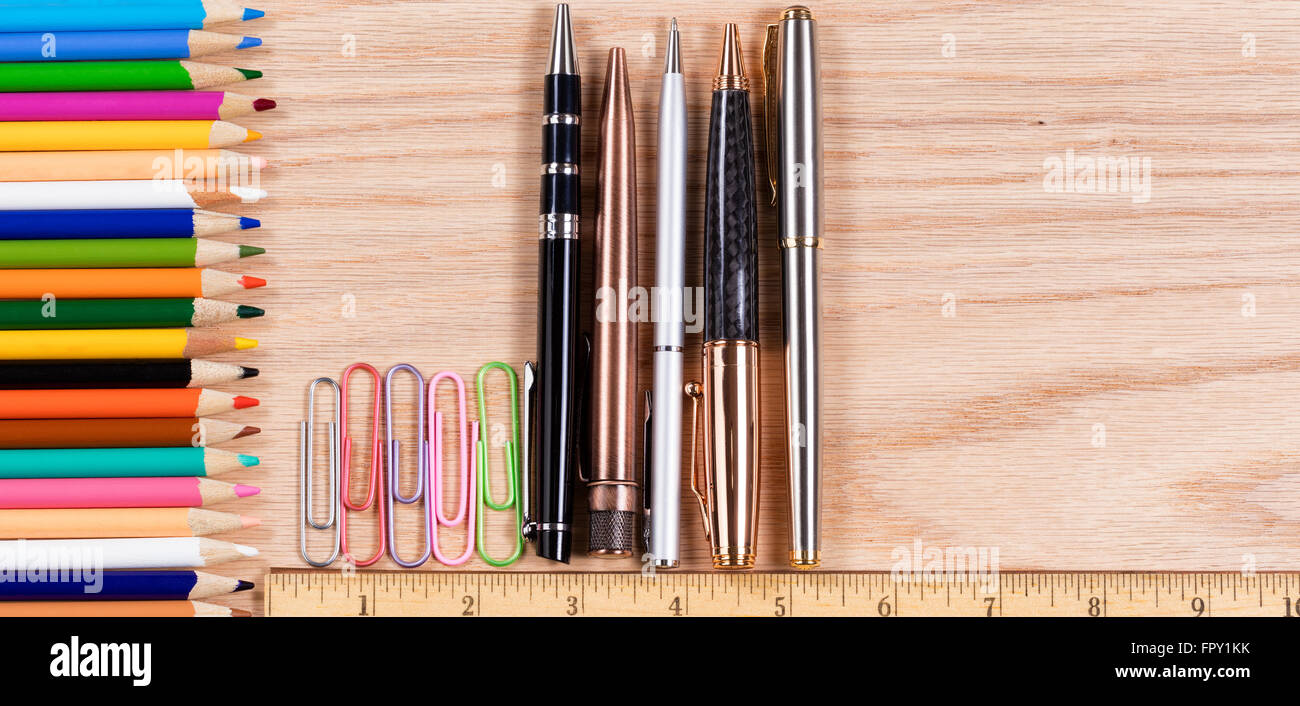Overhead view of desktop pencils, pens and paper clips with ruler on ...