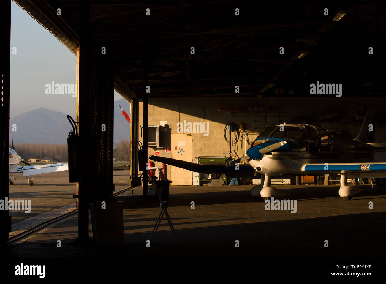 Small airport hangar scene with aircraft in late afternoon light Stock ...