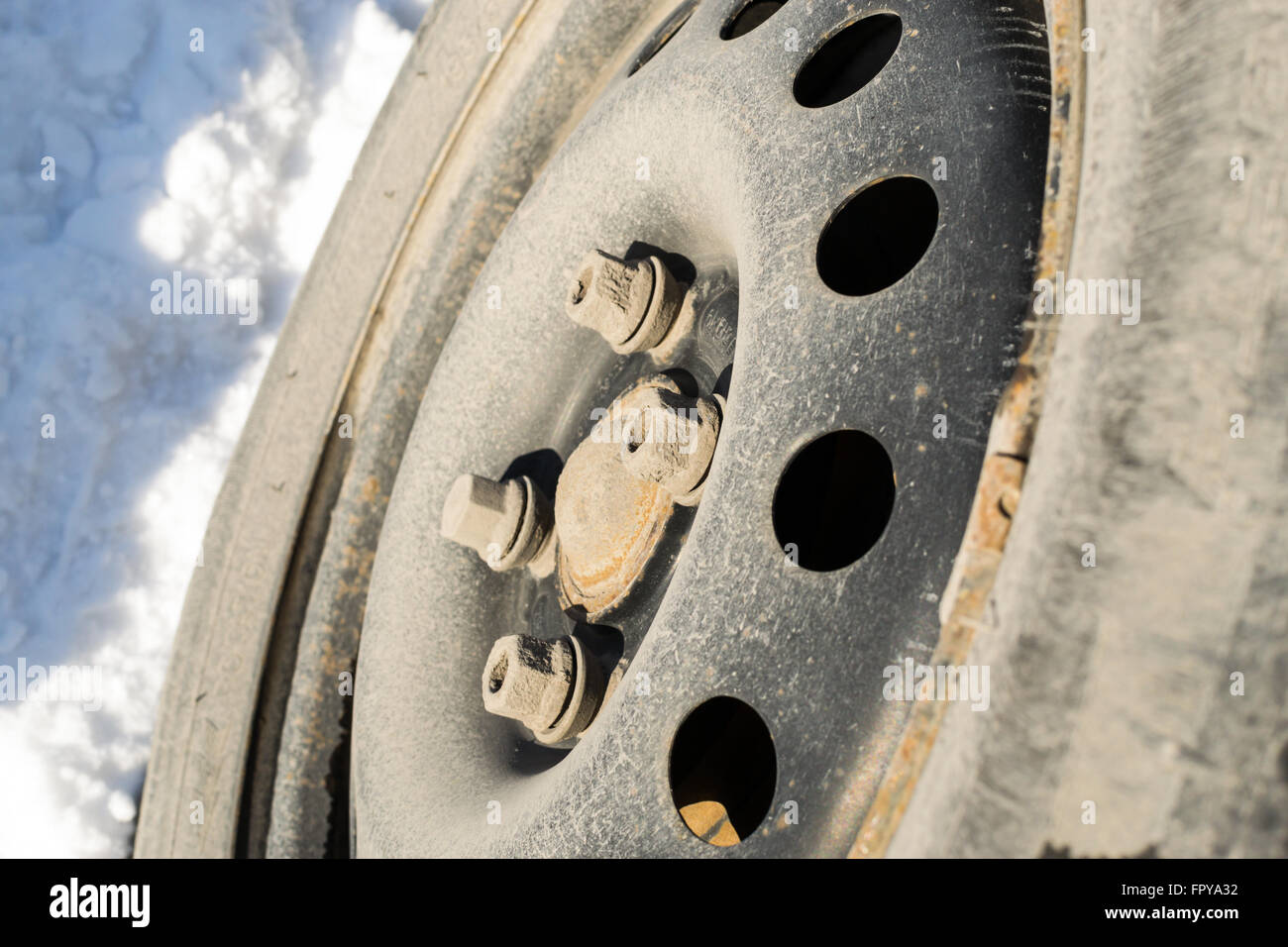 Closeup of car wheel with a removed hubcap. The tyres are worn with ...