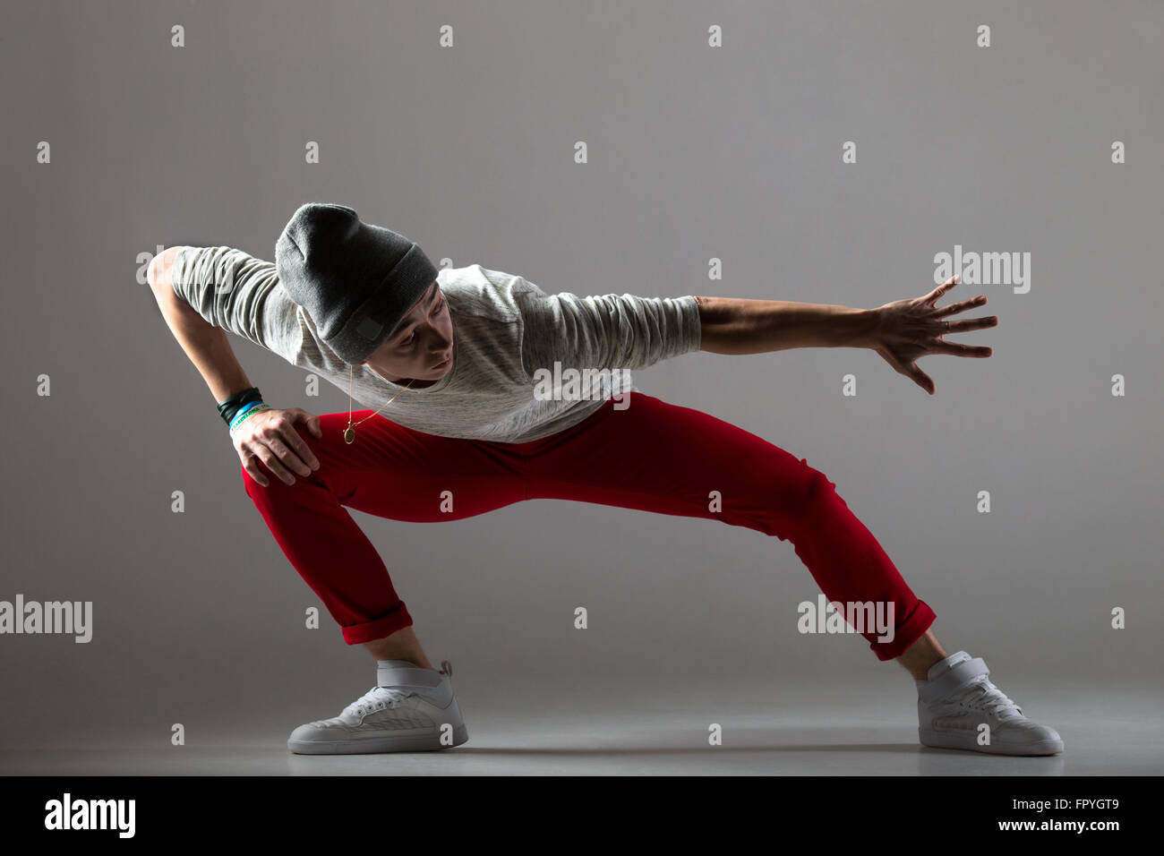 One attractive fit young man in casual red jeans working out, dancing ...