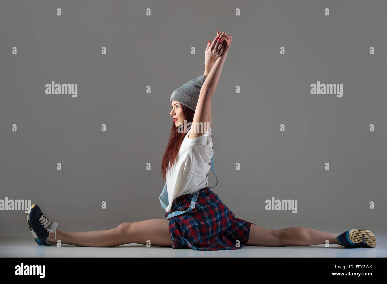 One fit young woman wearing casual plaid shirt sitting in splits ...