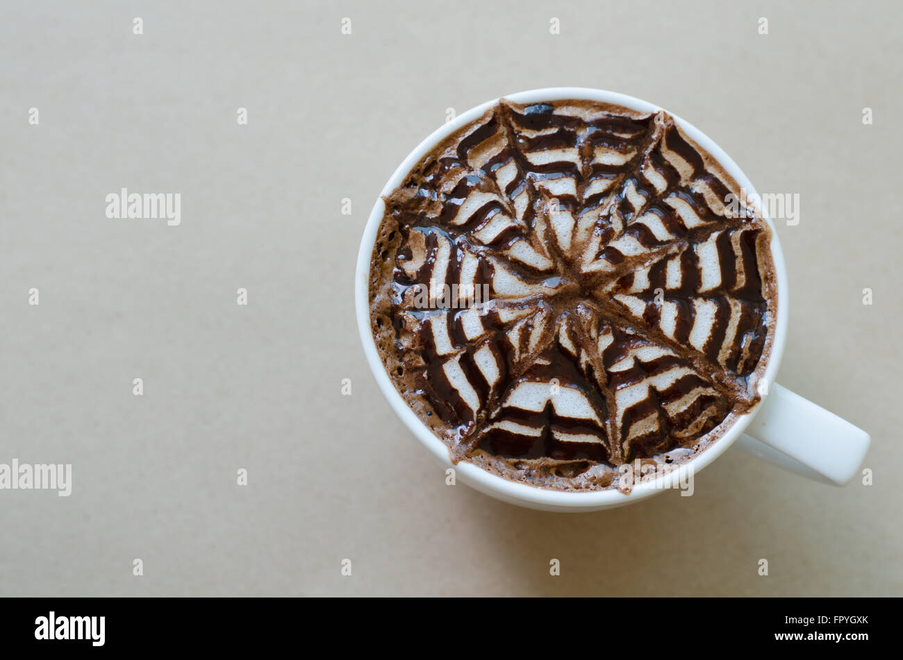 a cup of coffee with latte art on brown paper background Stock Photo ...