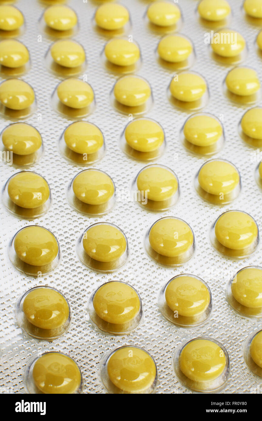 Yellow and round tablets in a factory packing Stock Photo - Alamy