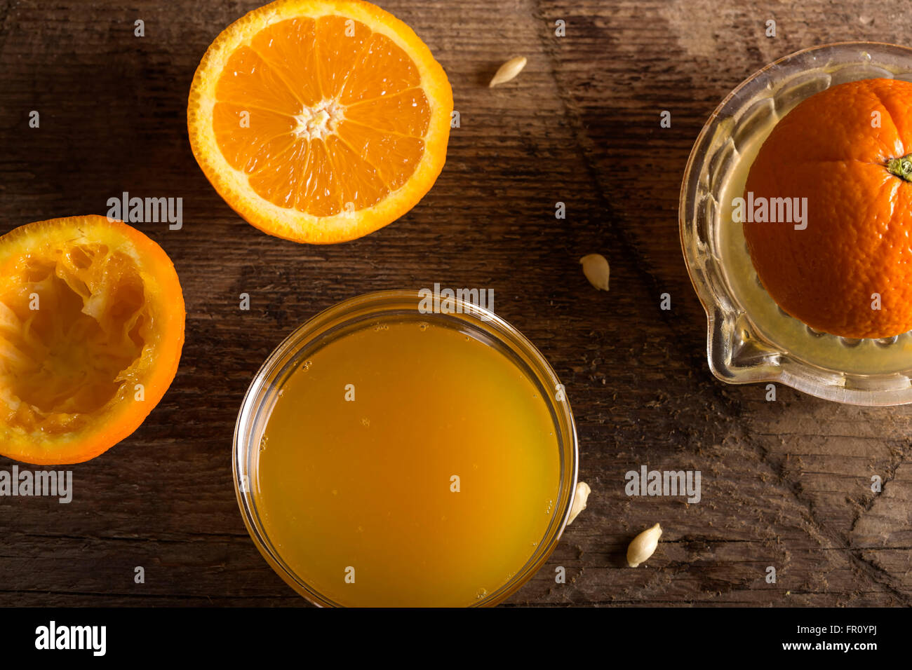 Bowl of fresh orange juice and juicer on wooden background Stock Photo ...