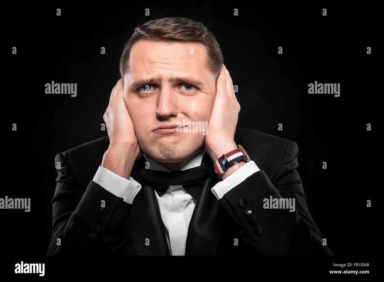 Man covering his ears Stock Photo - Alamy