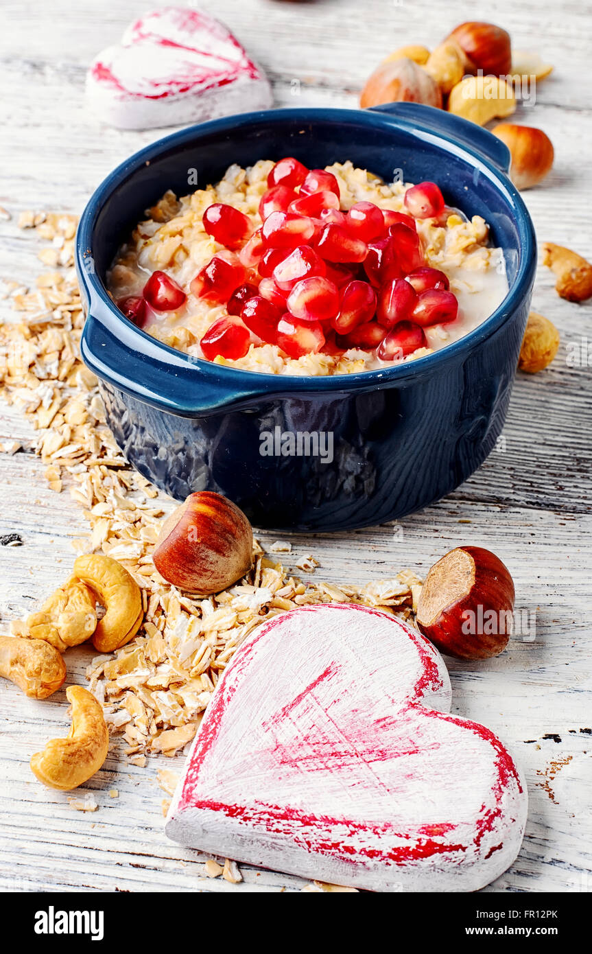 Cooked oat cereal with fruit and nuts on a background of two wooden ...
