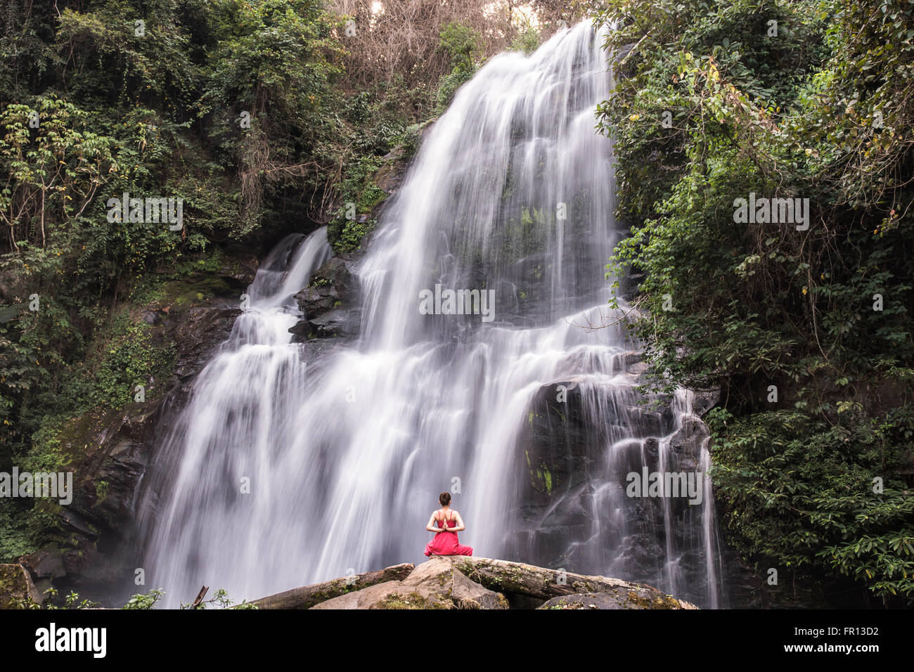 Female doing yoga outdoor at beautiful waterfall. Exercise for Health ...