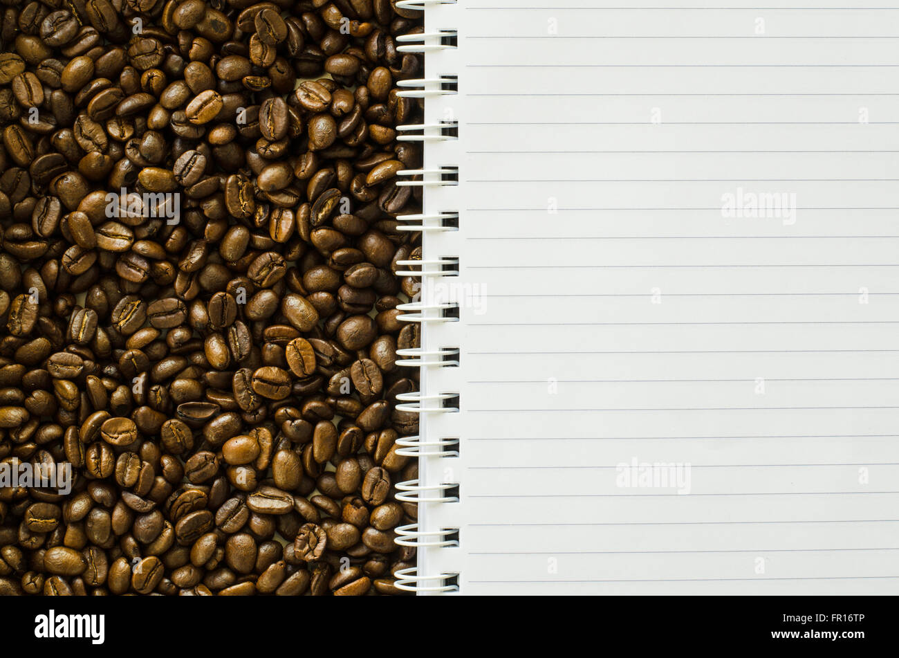 Notebook on coffee bean background Stock Photo - Alamy