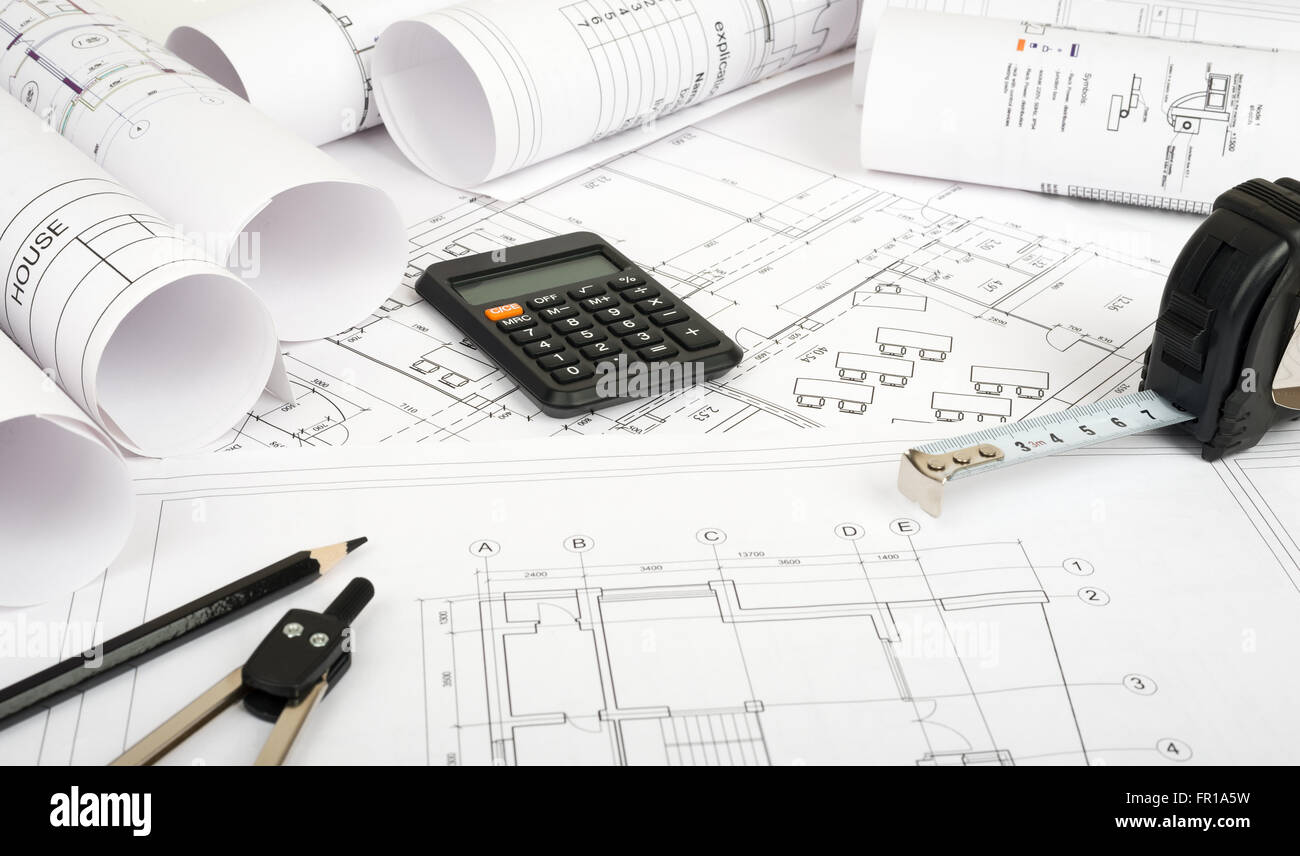 Architecture plan and rolls of blueprints with meter and calculator ...