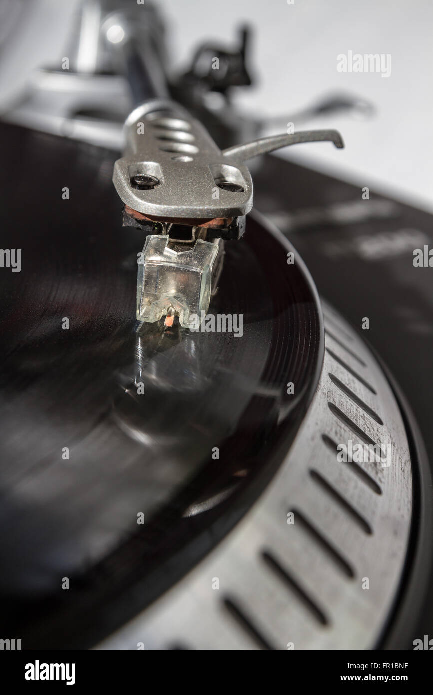 Professional turntable playing vinyl records with music. Close up on ...