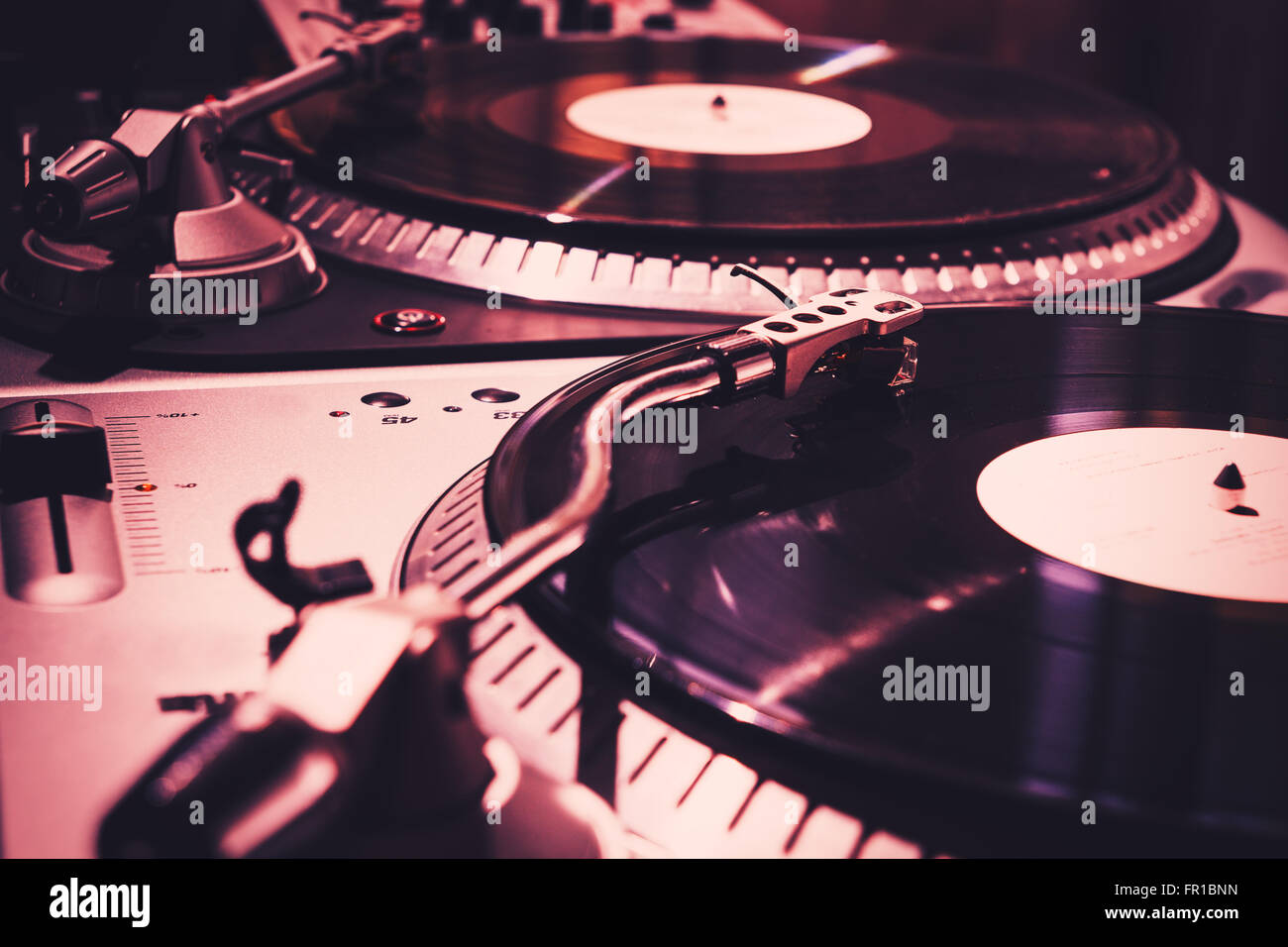 Professional turntable playing vinyl records with music. Close up on ...