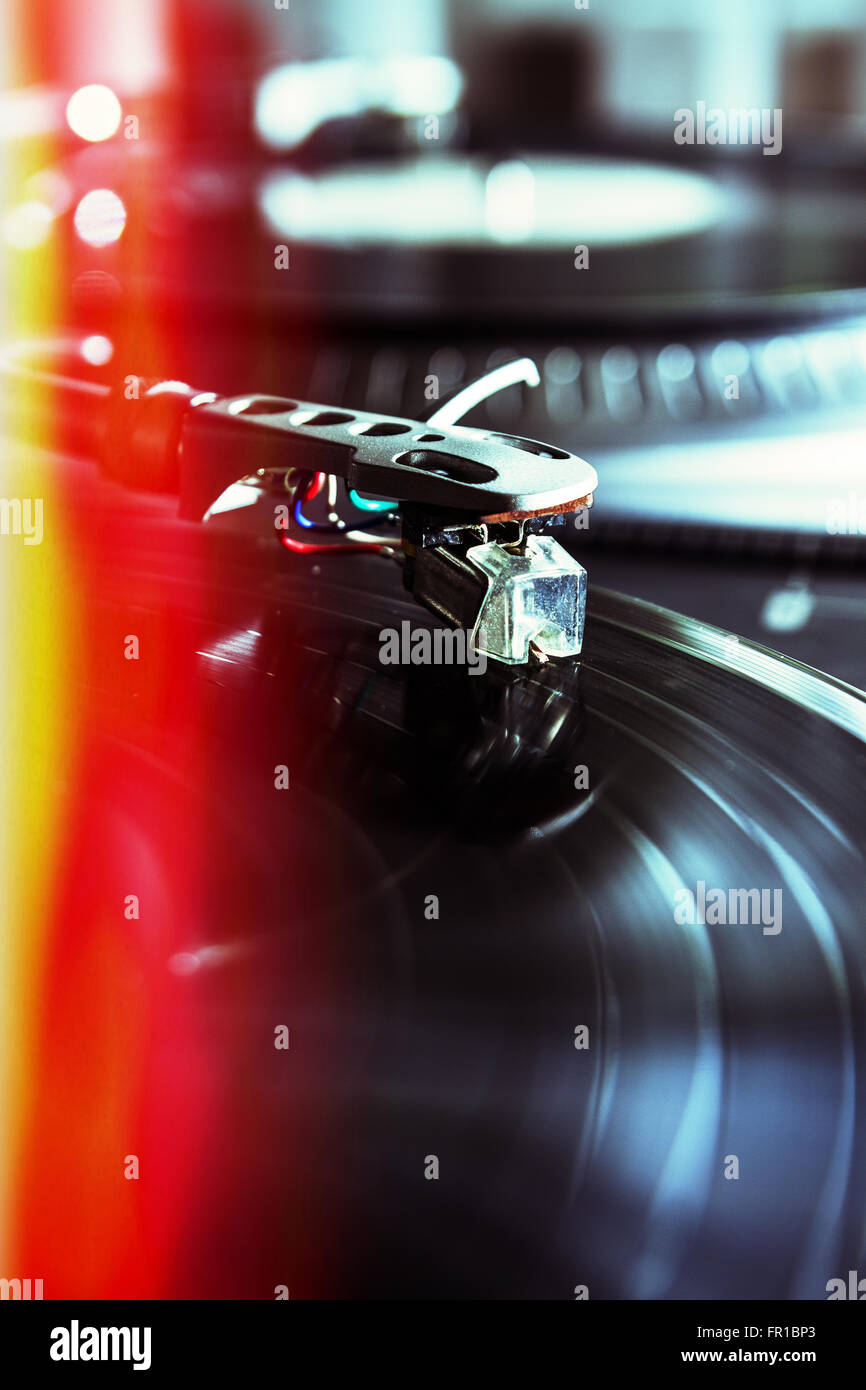 Professional turntable playing vinyl records with music. Close up on ...
