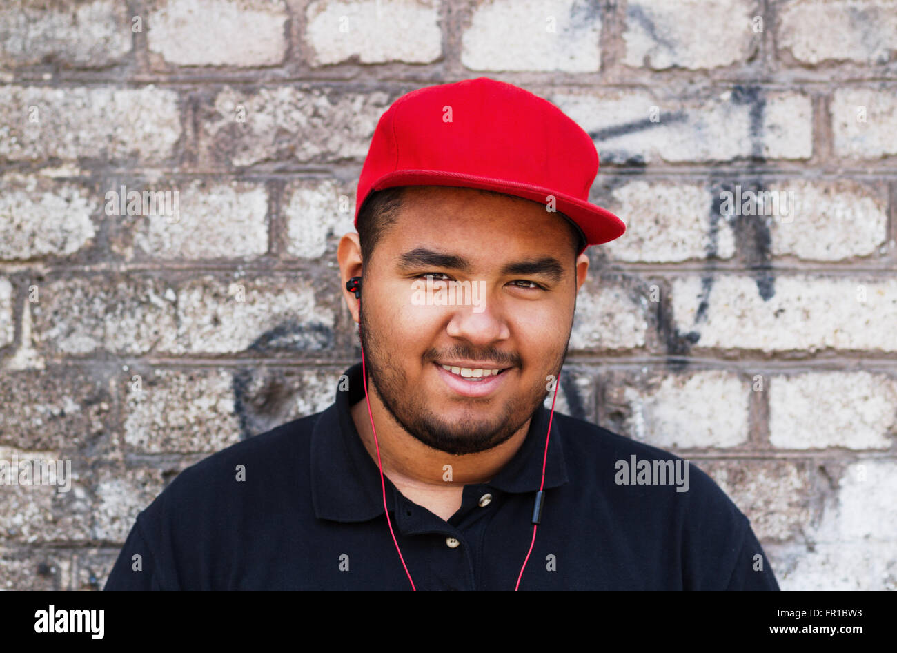 Portrait of a young African boy enjoying the music through his red ...
