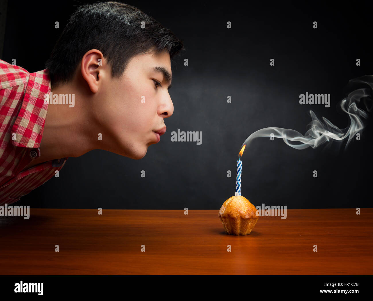 Birthday boy blowing out the candle Stock Photo - Alamy