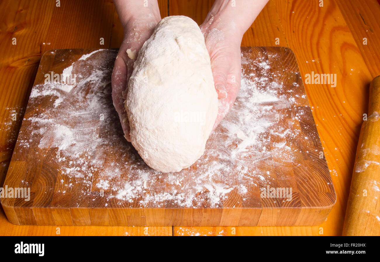 Making dough by female hands on wooden table background Stock Photo - Alamy