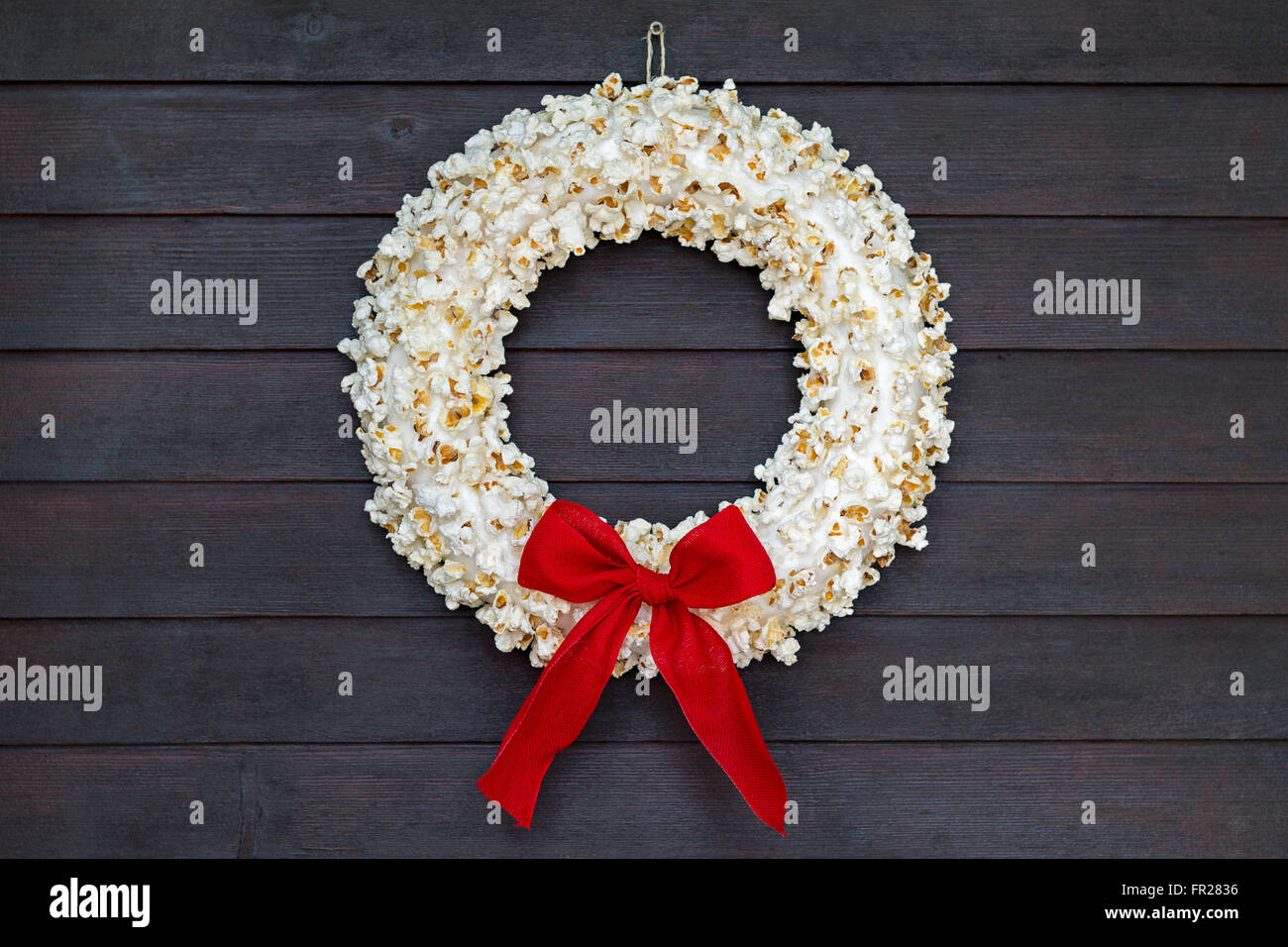Popcorn wreath with red bow hanging on dark wooden door Stock Photo - Alamy
