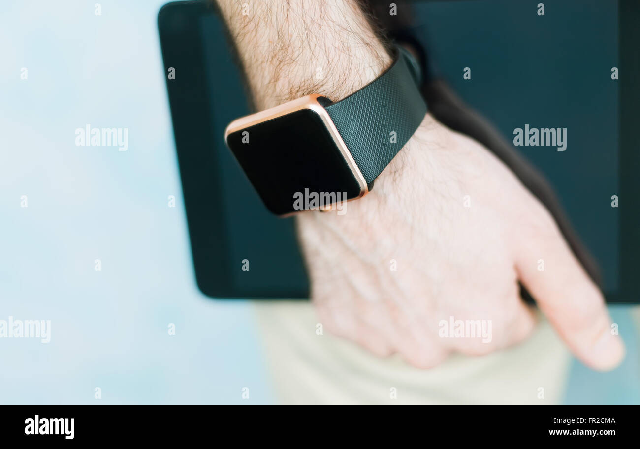 Male hand holding two modern digital devices to be always connected to ...