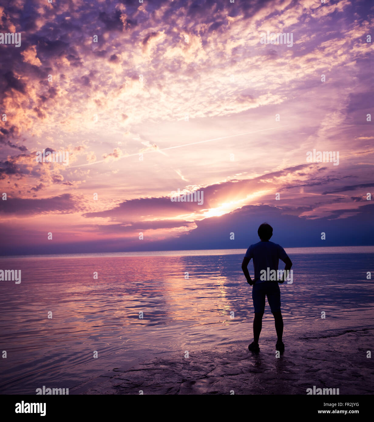 Silhouette of Man Enjoying Sunset at Sea Stock Photo - Alamy