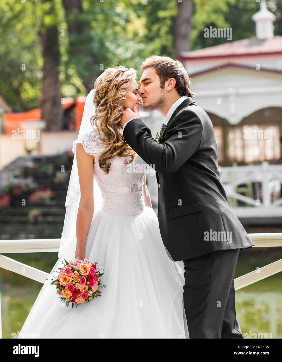 Beautiful wedding couple in park. They kiss and hug each other Stock ...