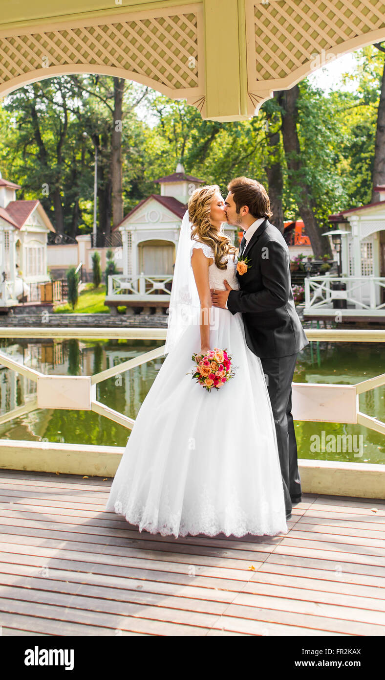 Beautiful wedding couple in park. They kiss and hug each other Stock ...