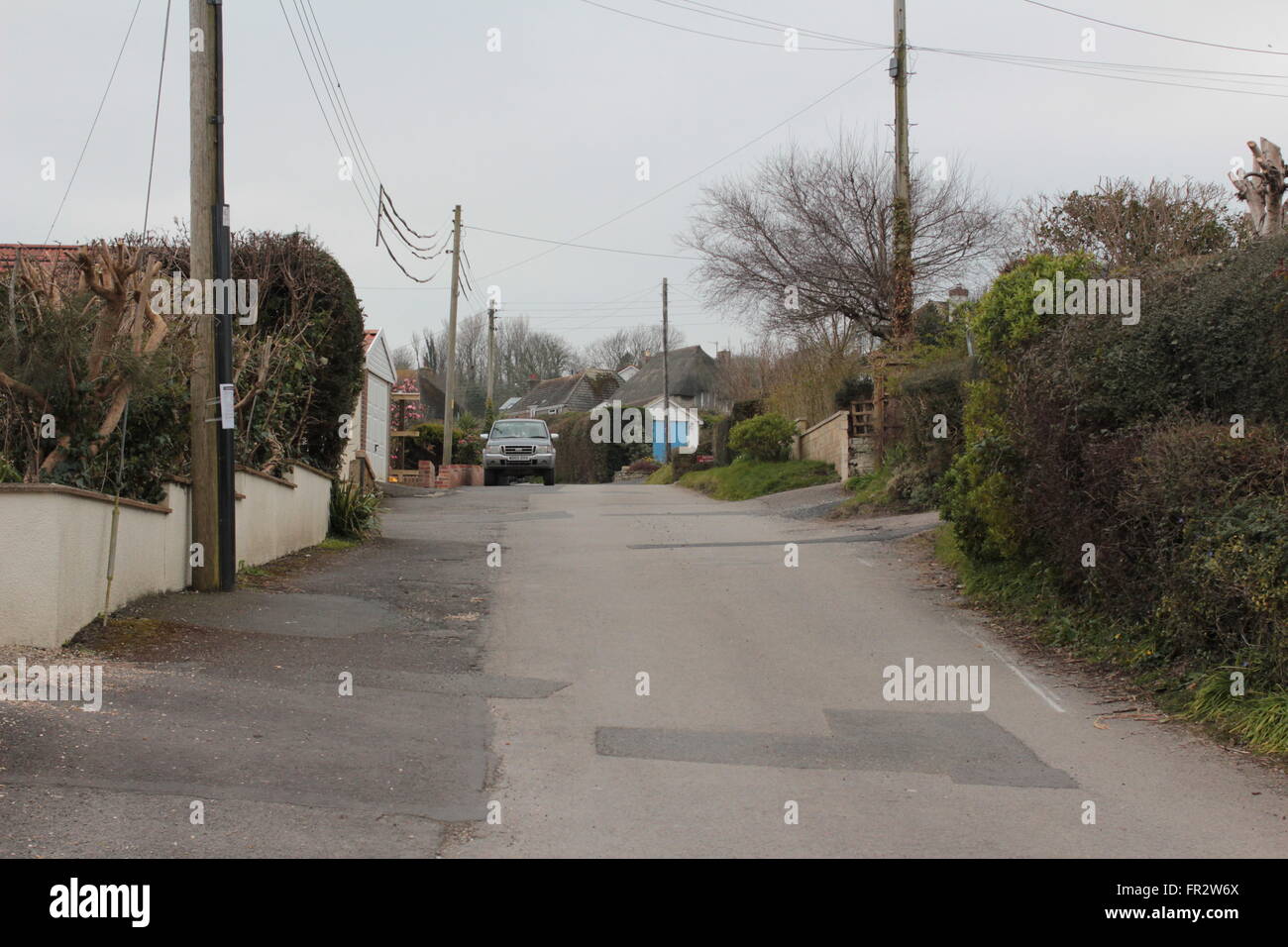 View up a road with a car and telephone wires Stock Photo - Alamy