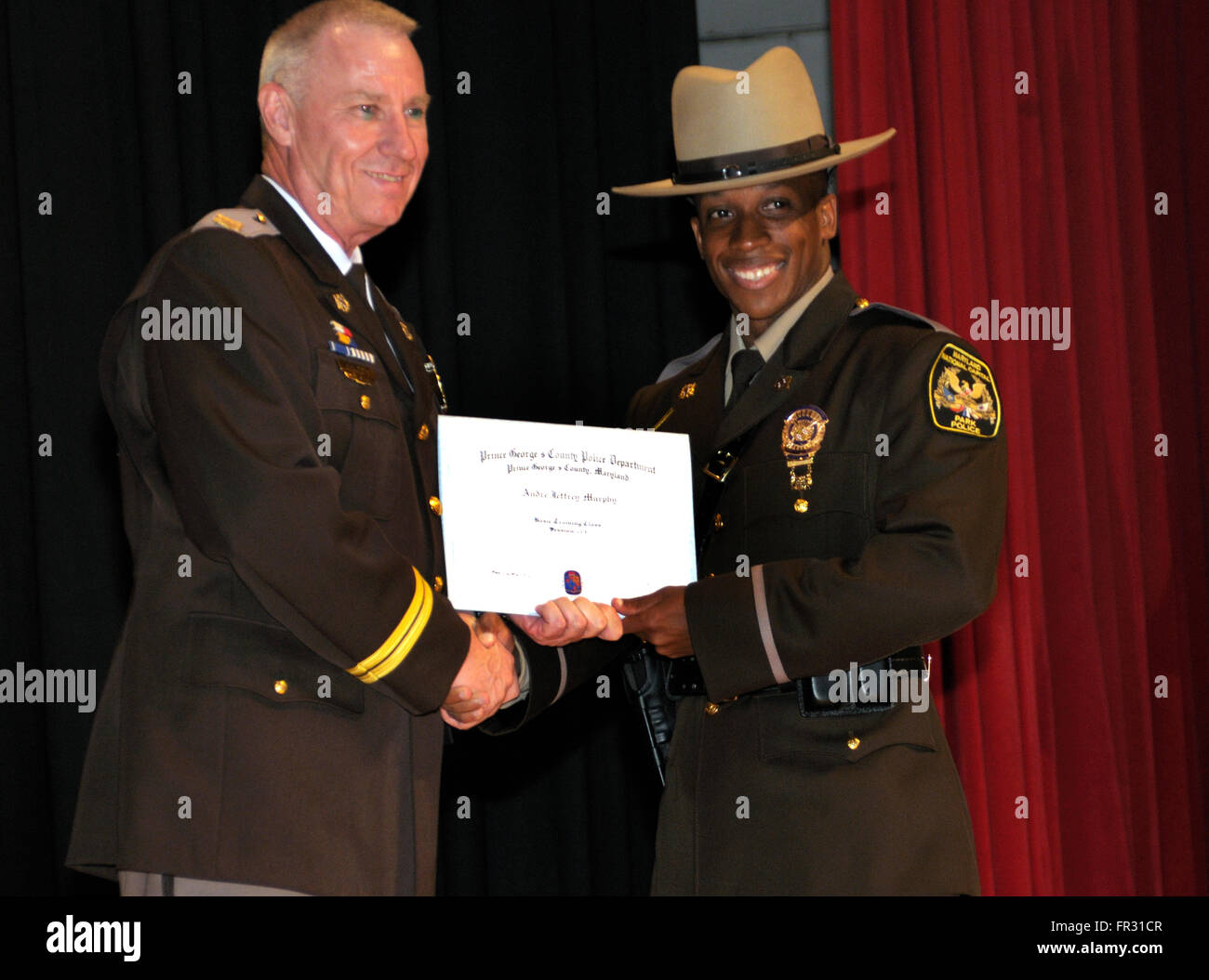 Police officer gets an award from his chief at an awards assembly Stock ...