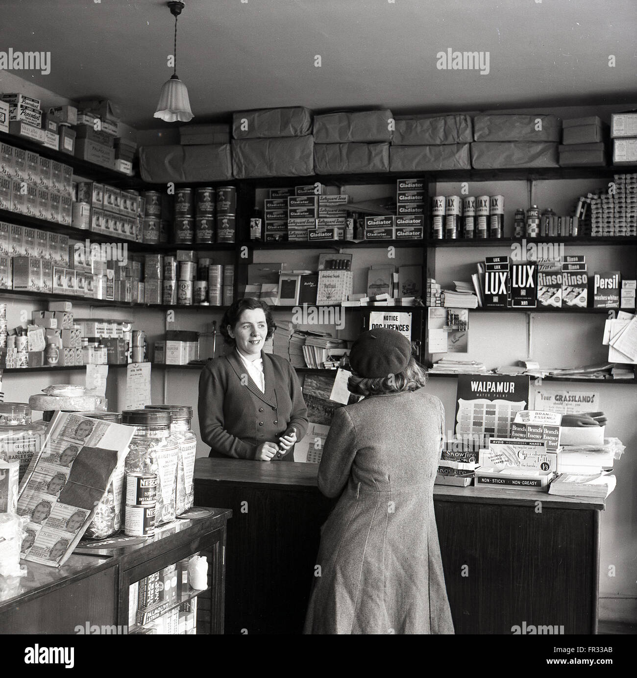 1950s historical, a lady chatting to a female shop assistant at the ...