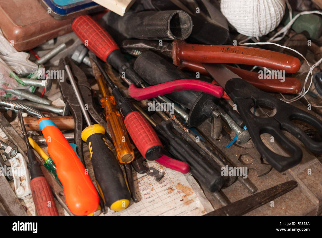 An untidy workbench full of dusty old tools and screws as a background ...