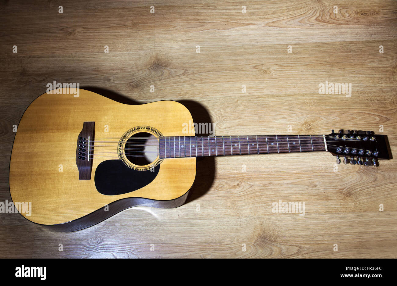 yellow acoustic 12-strings guitar lying on wooden floor closeup Stock ...