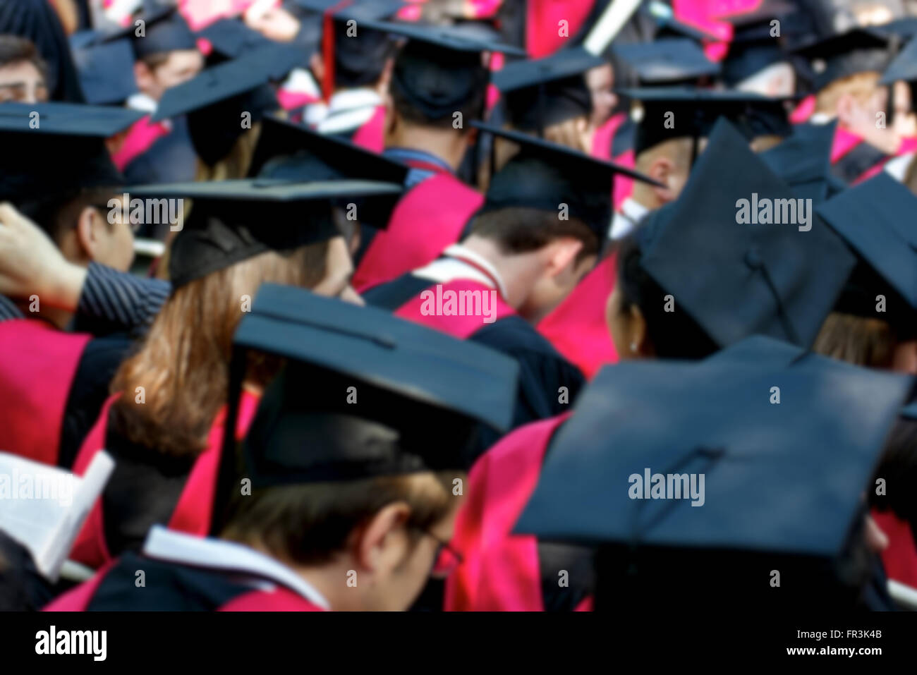 Blurred background of students in cap and gown at their graduation ...