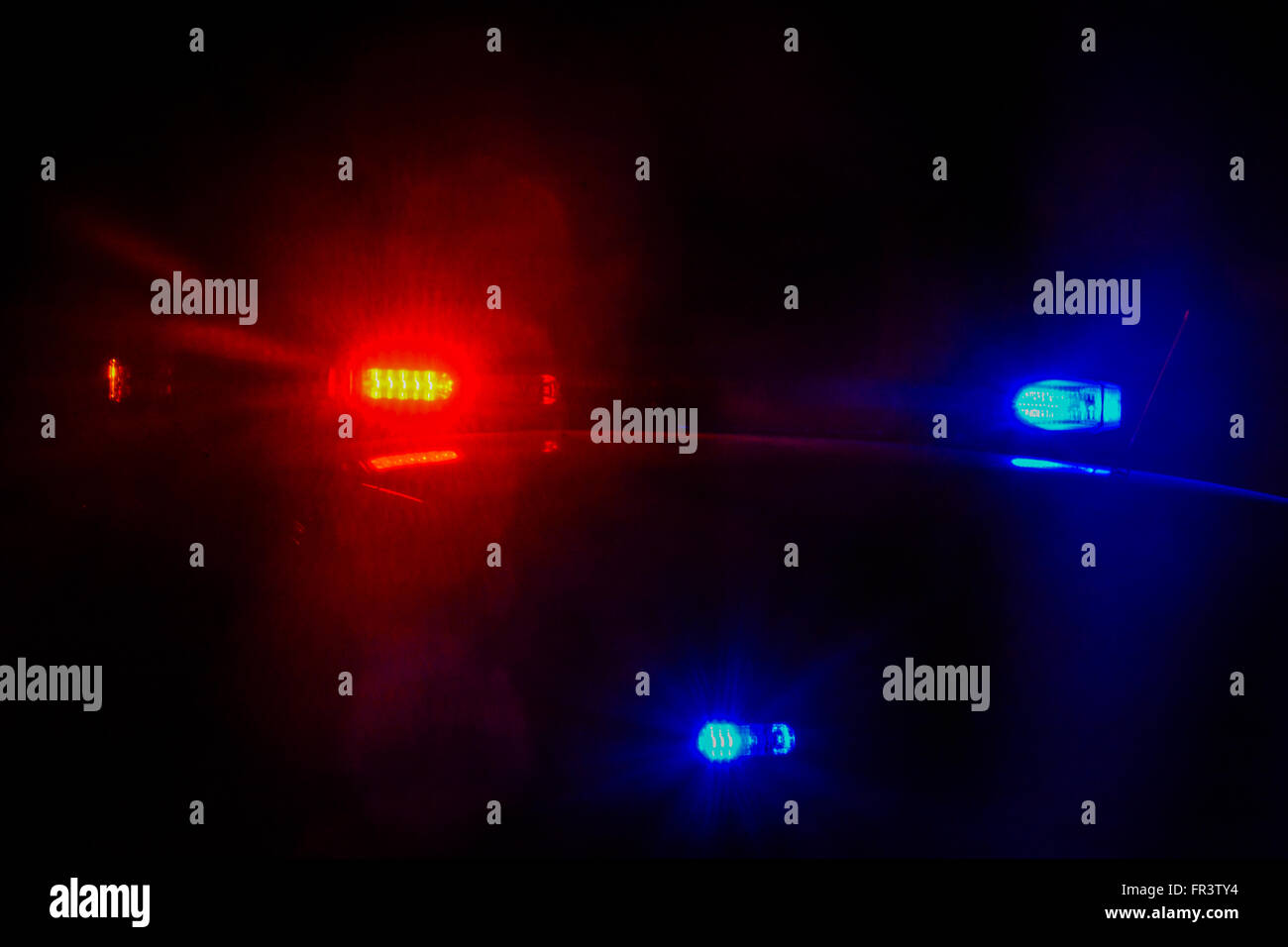 Red and blue flashing police car lights atop a patrol car at night ...