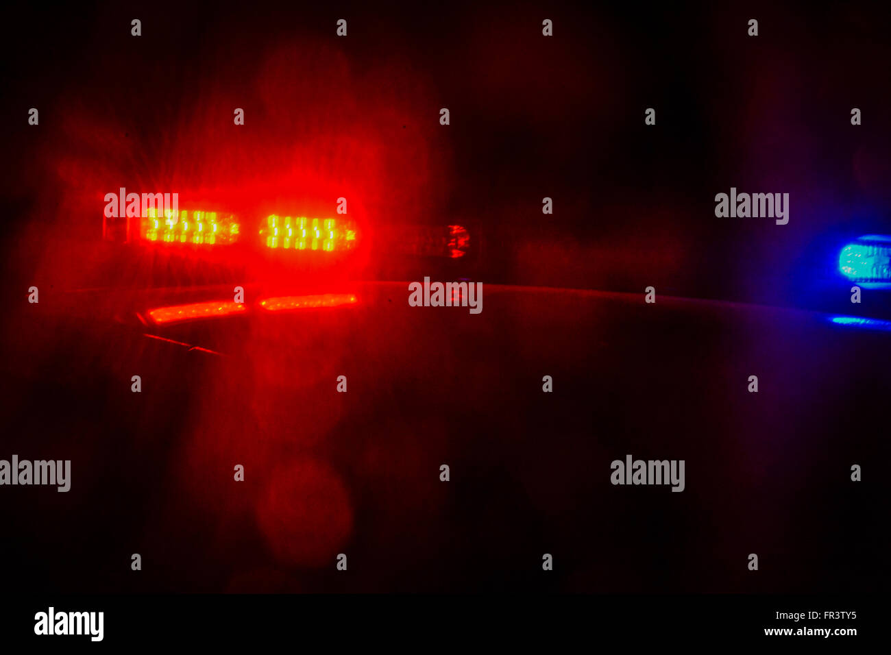 Red and blue flashing police car lights atop a patrol car at night ...