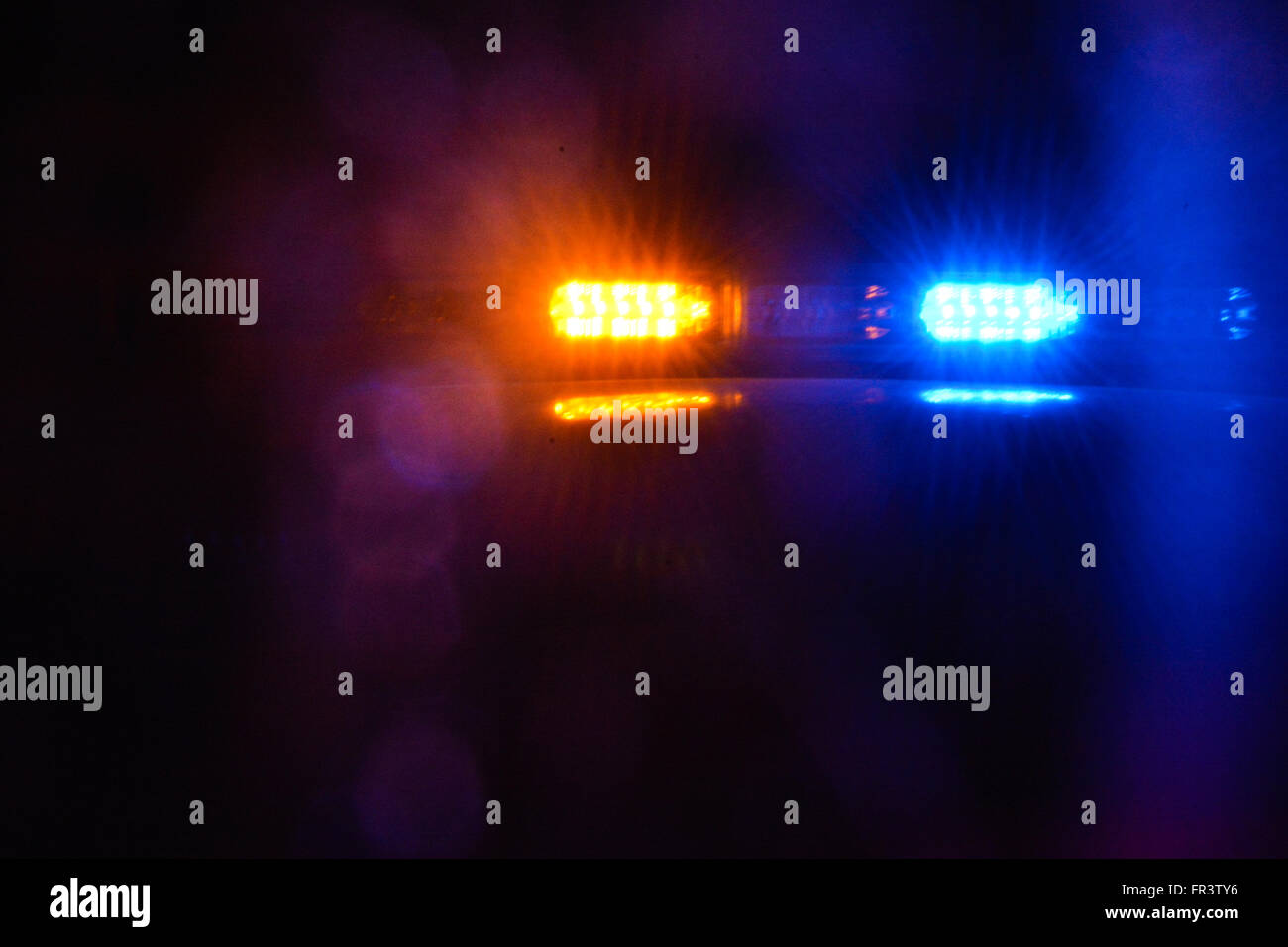 Red and blue flashing police car lights atop a patrol car at night ...