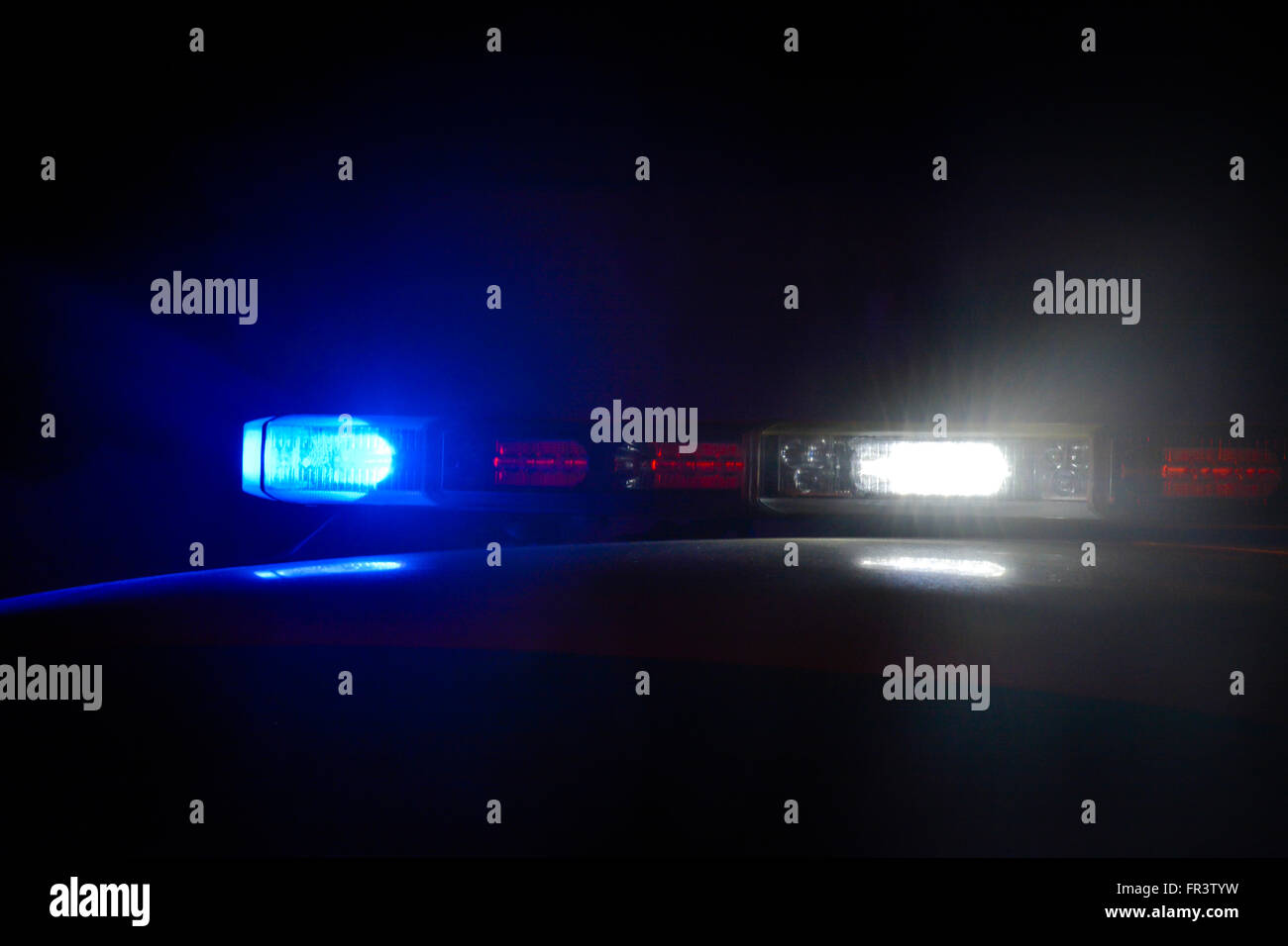 Red and white flashing police car lights atop a patrol car at night ...