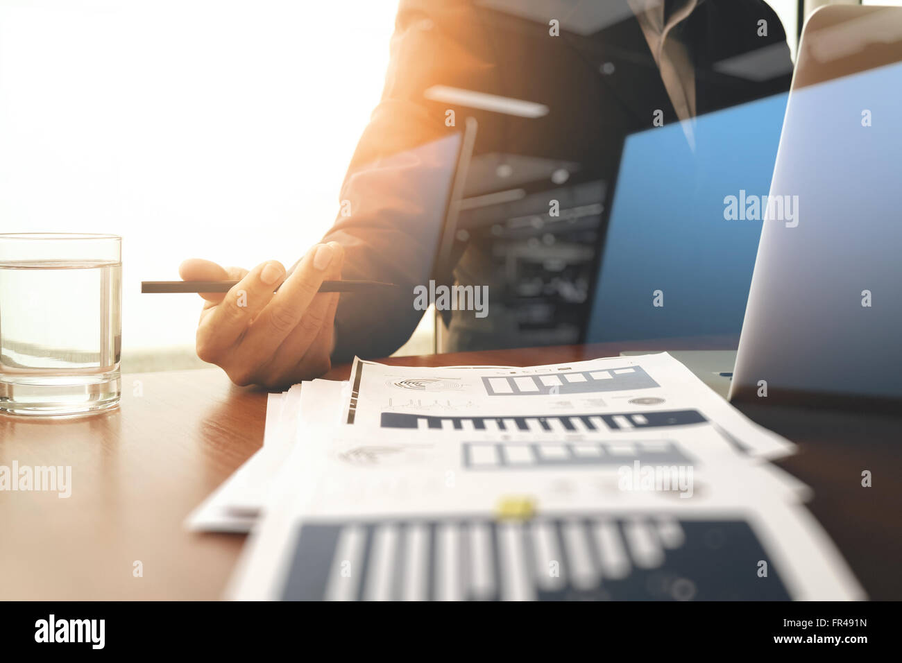 business documents on office table with laptop computer and graph ...