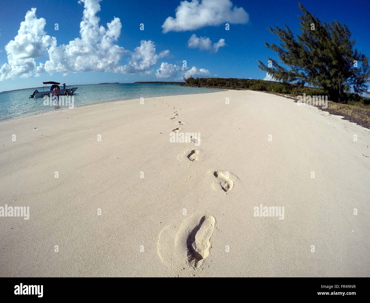 Nature: Footprints in the sands with a man and boat in the background ...
