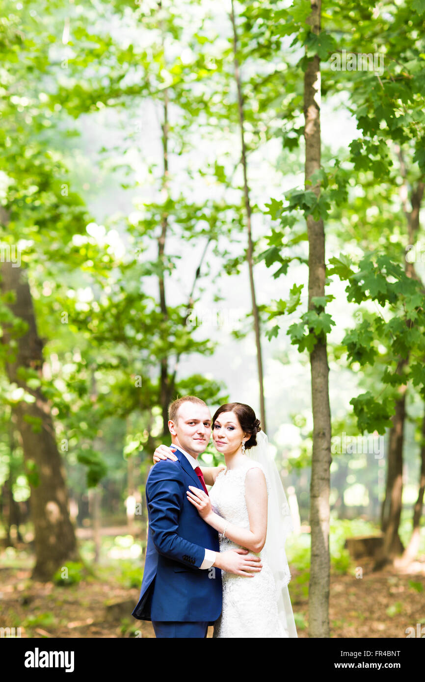 Beautiful wedding couple in park. They kiss and hug each other Stock ...
