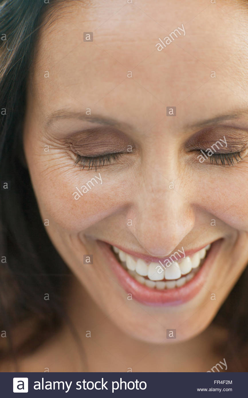 middle aged woman laughing with eyes closed Stock Photo - Alamy