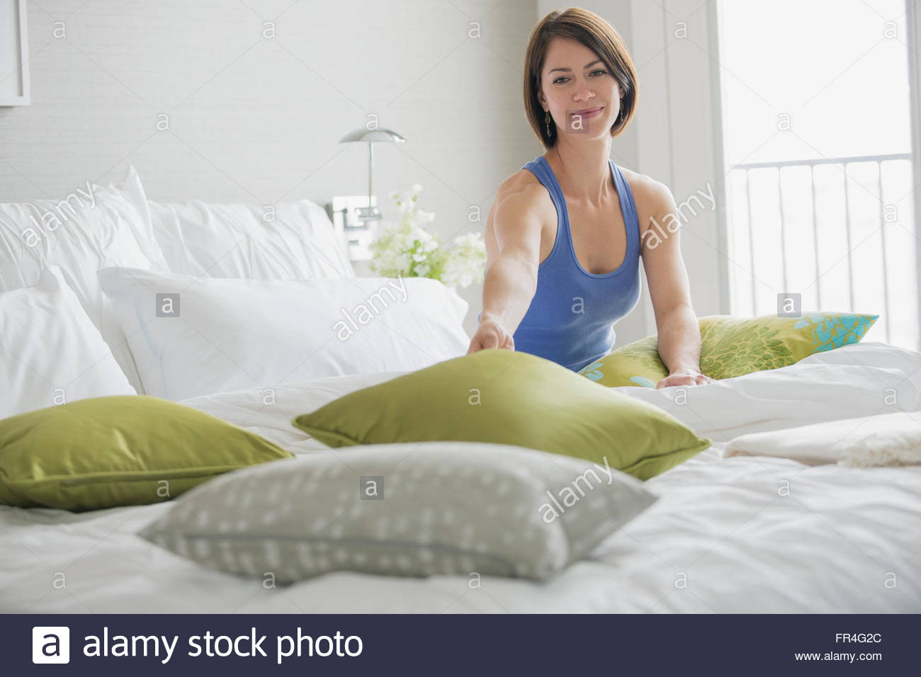 Woman fluffing pillows hi-res stock photography and images - Alamy