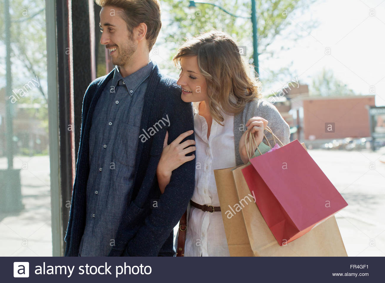 Young adult couple browsing in store window Stock Photo - Alamy