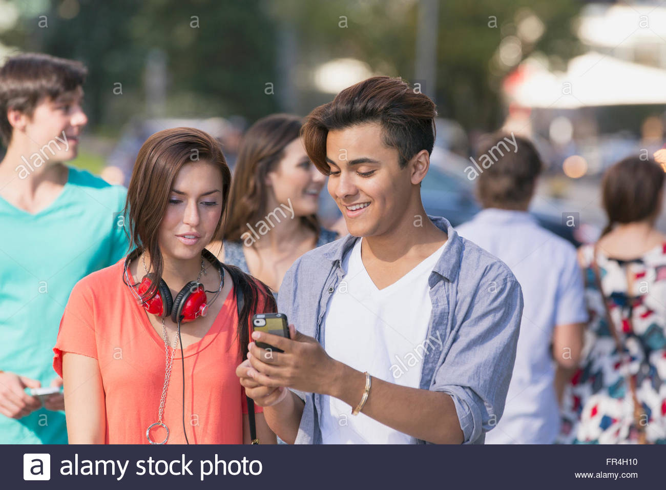 teenagers using technology while walking downtown Stock Photo - Alamy