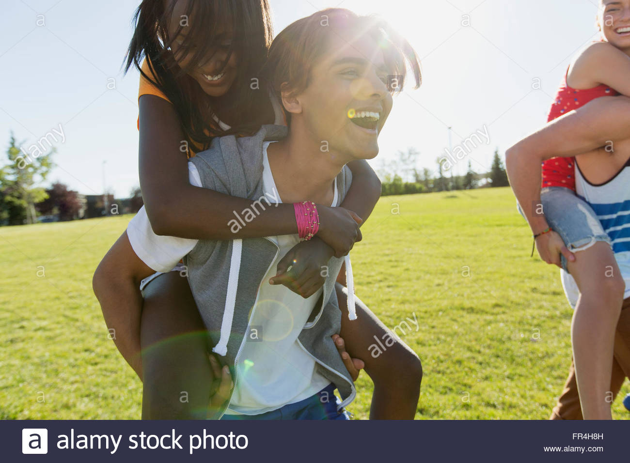 Girl giving piggy ride to boy hi-res stock photography and images - Alamy