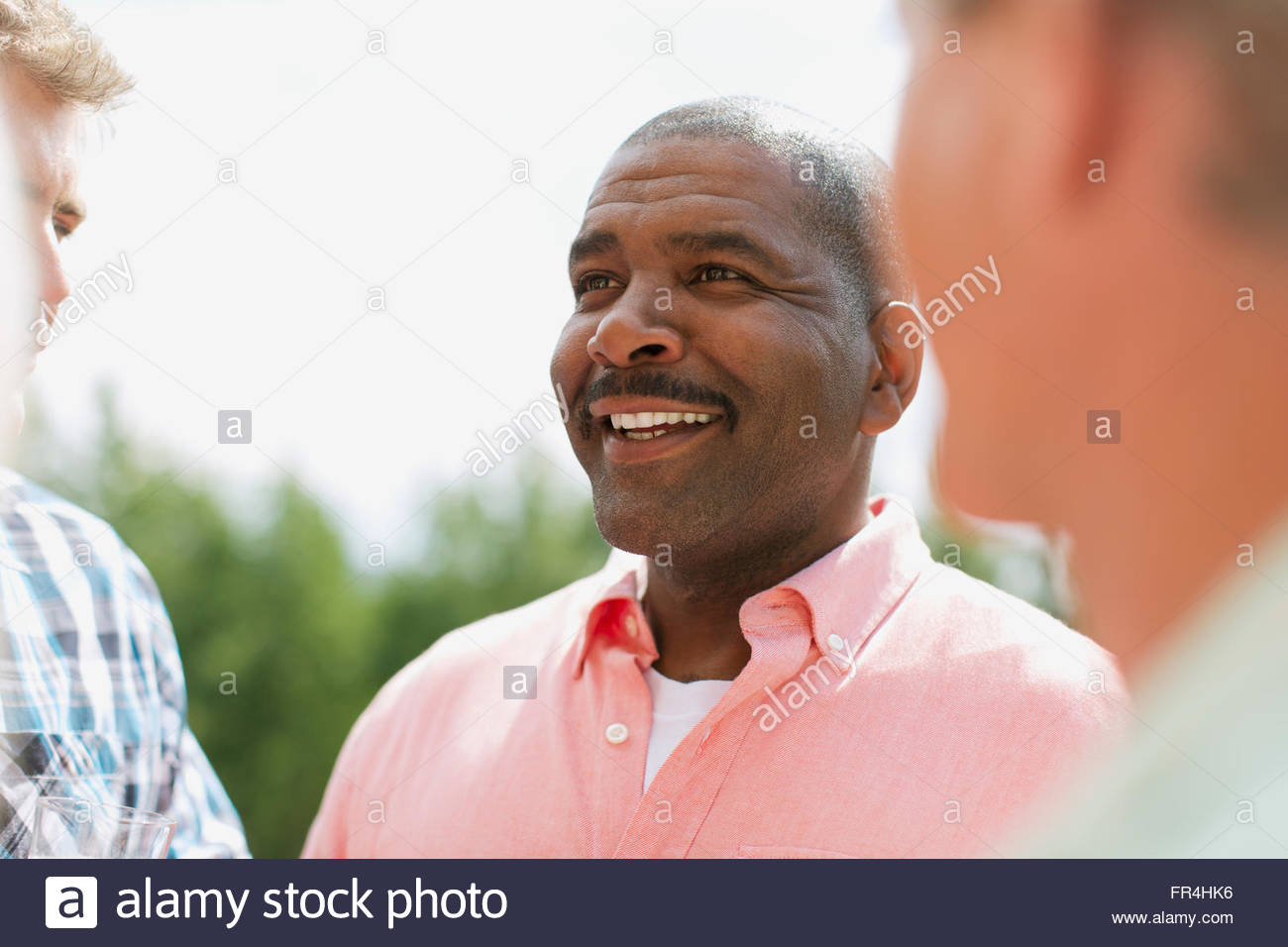 three men having a conversation outdoors Stock Photo - Alamy