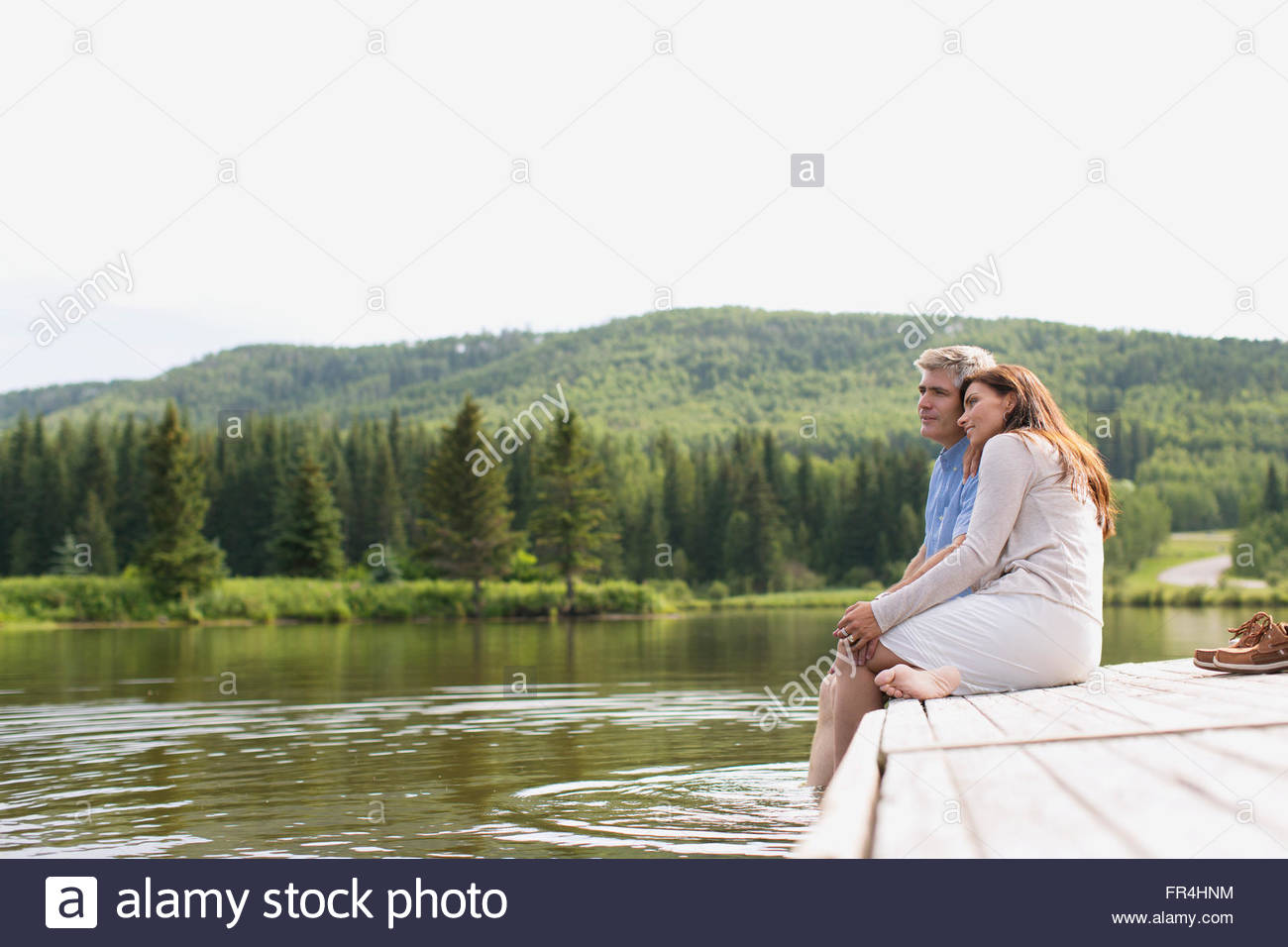 couple cuddling at the end of boat dock Stock Photo - Alamy