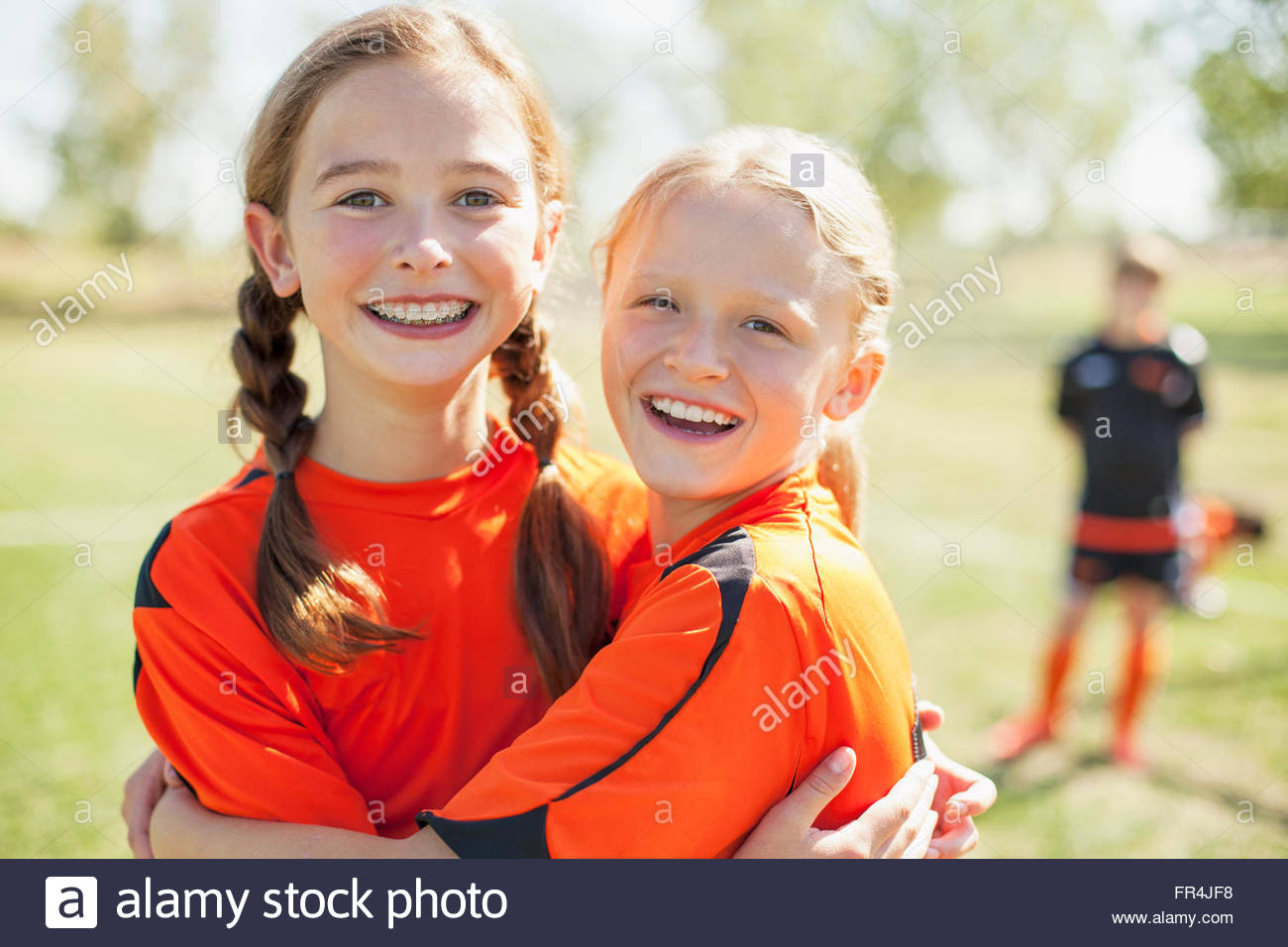 Girl soccer players smiling and hugging Stock Photo - Alamy