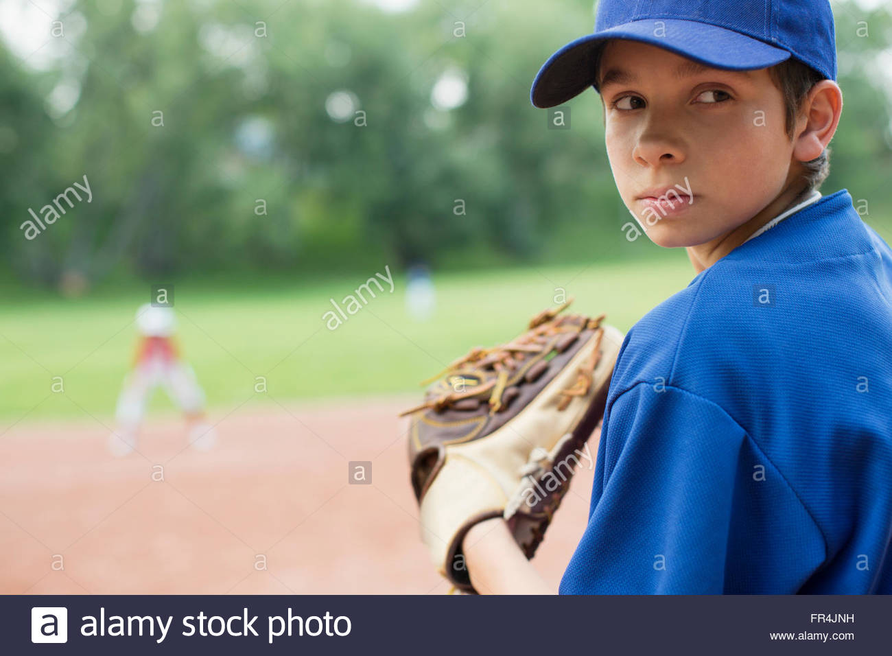 Young baseball pitcher looking back Stock Photo - Alamy